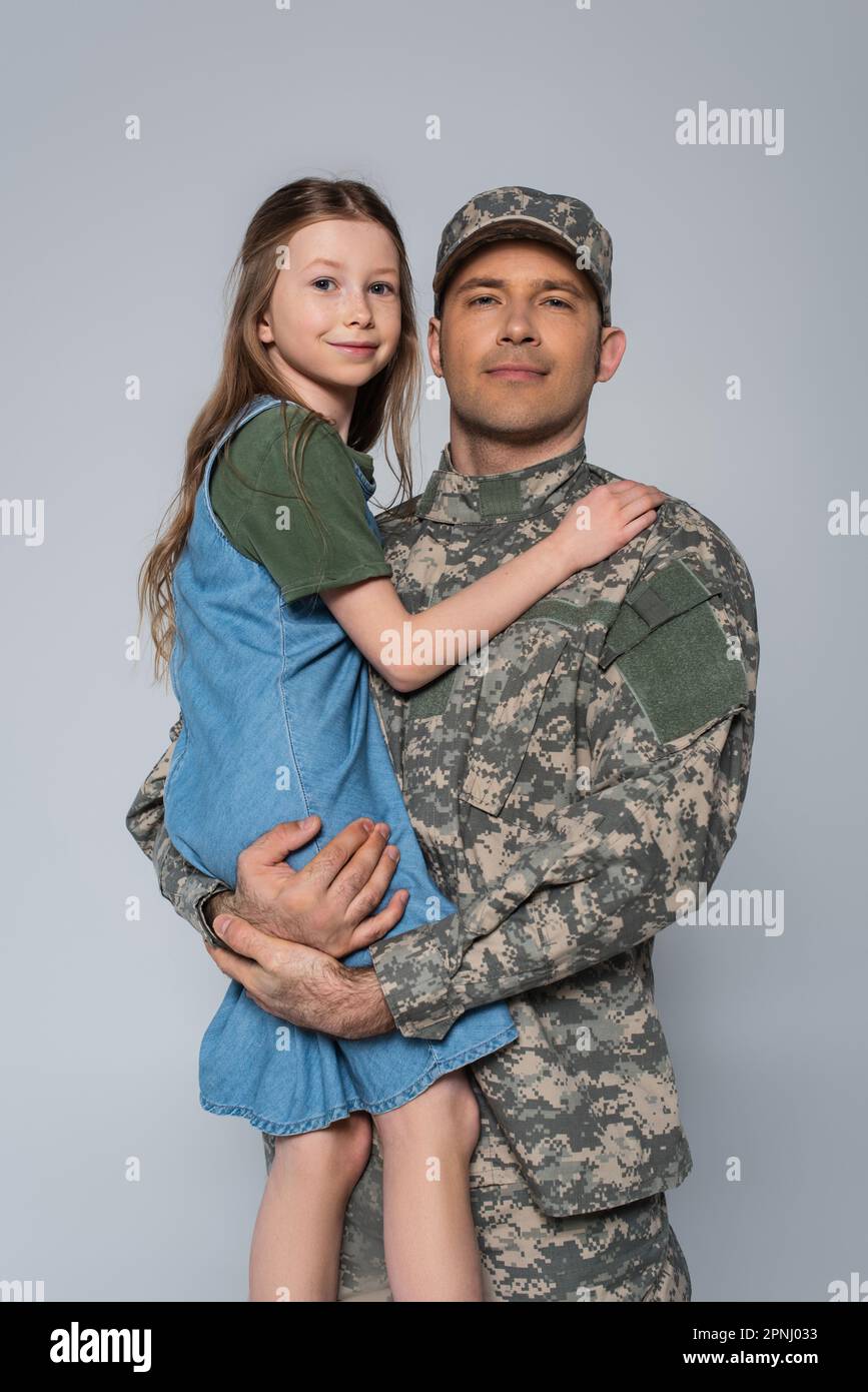 happy serviceman in military uniform holding in arms daughter isolated ...