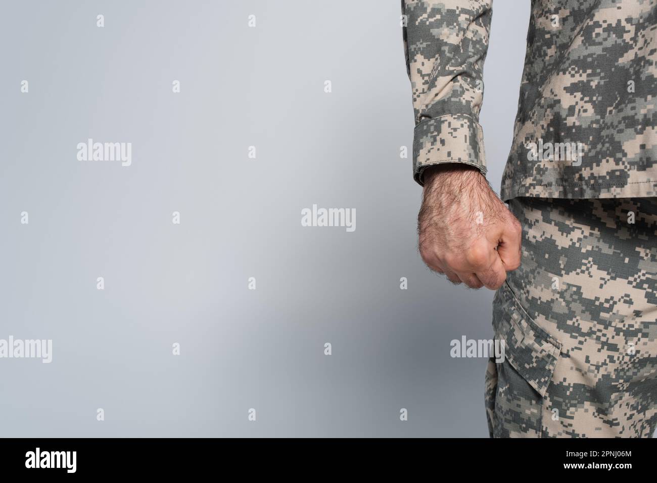 cropped view of patriotic soldier in military uniform standing with ...