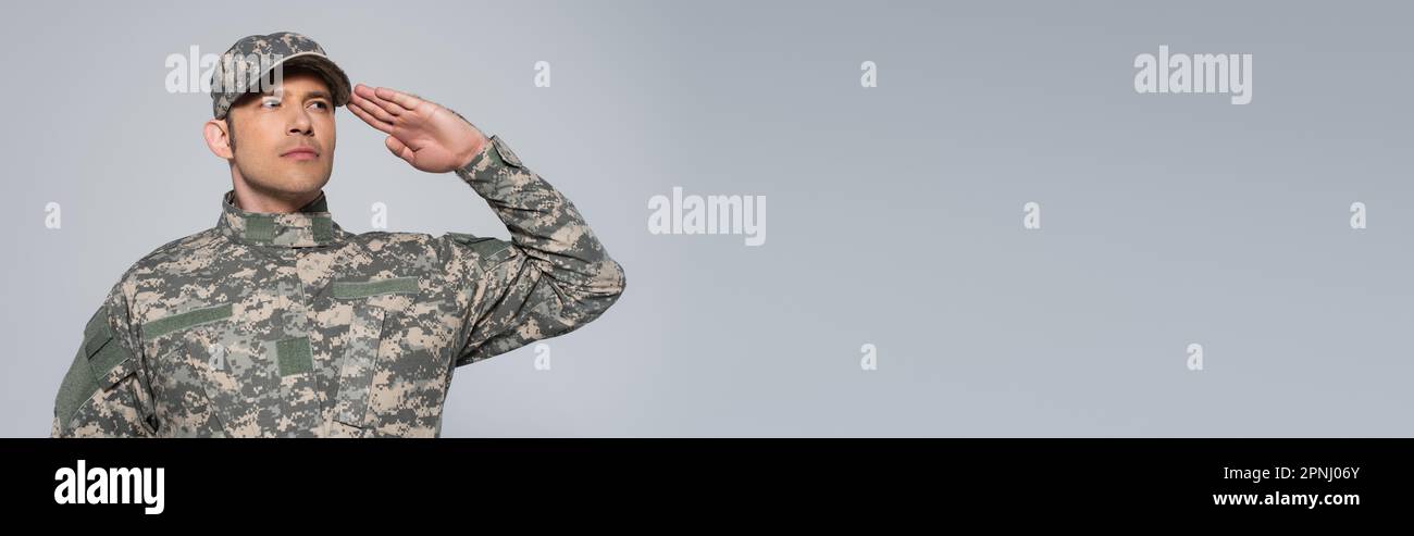 American soldier in military uniform with cap saluting during memorial ...