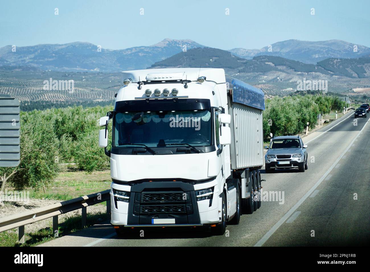 Truck on a highway - front view, mountains on second plan Stock Photo ...