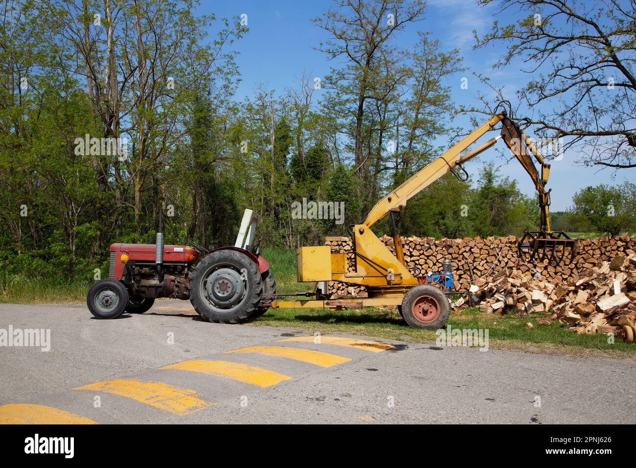 Old agricultural tractor with crane for loading wood log Stock Photo ...