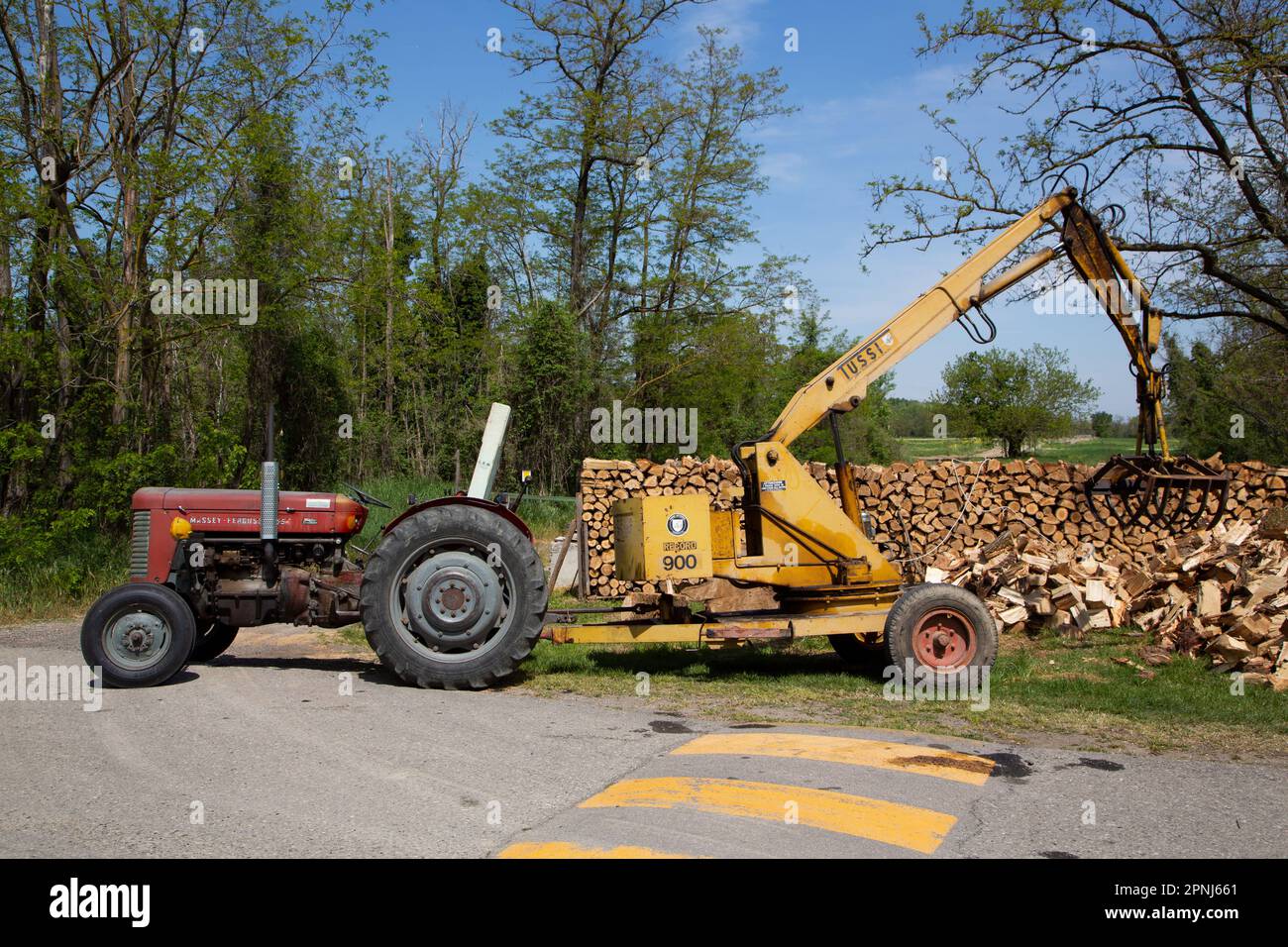 Old agricultural tractor with crane for loading wood log Stock Photo ...