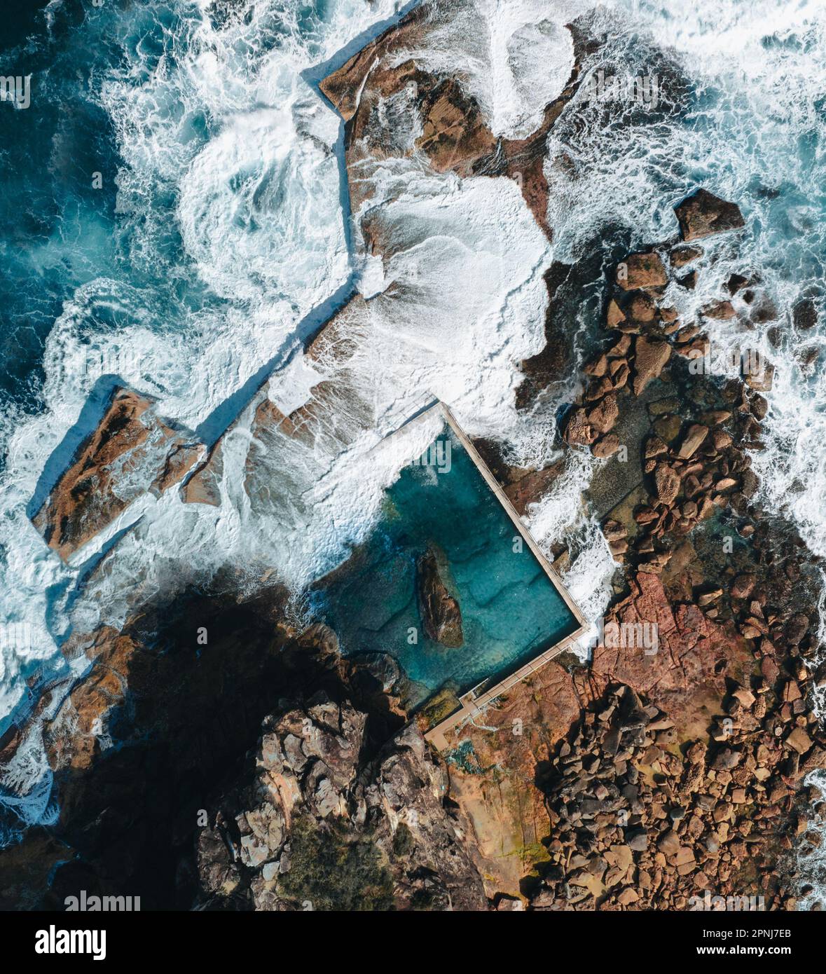 Aerial view early morning light with ocean waves flowing over rocks ...