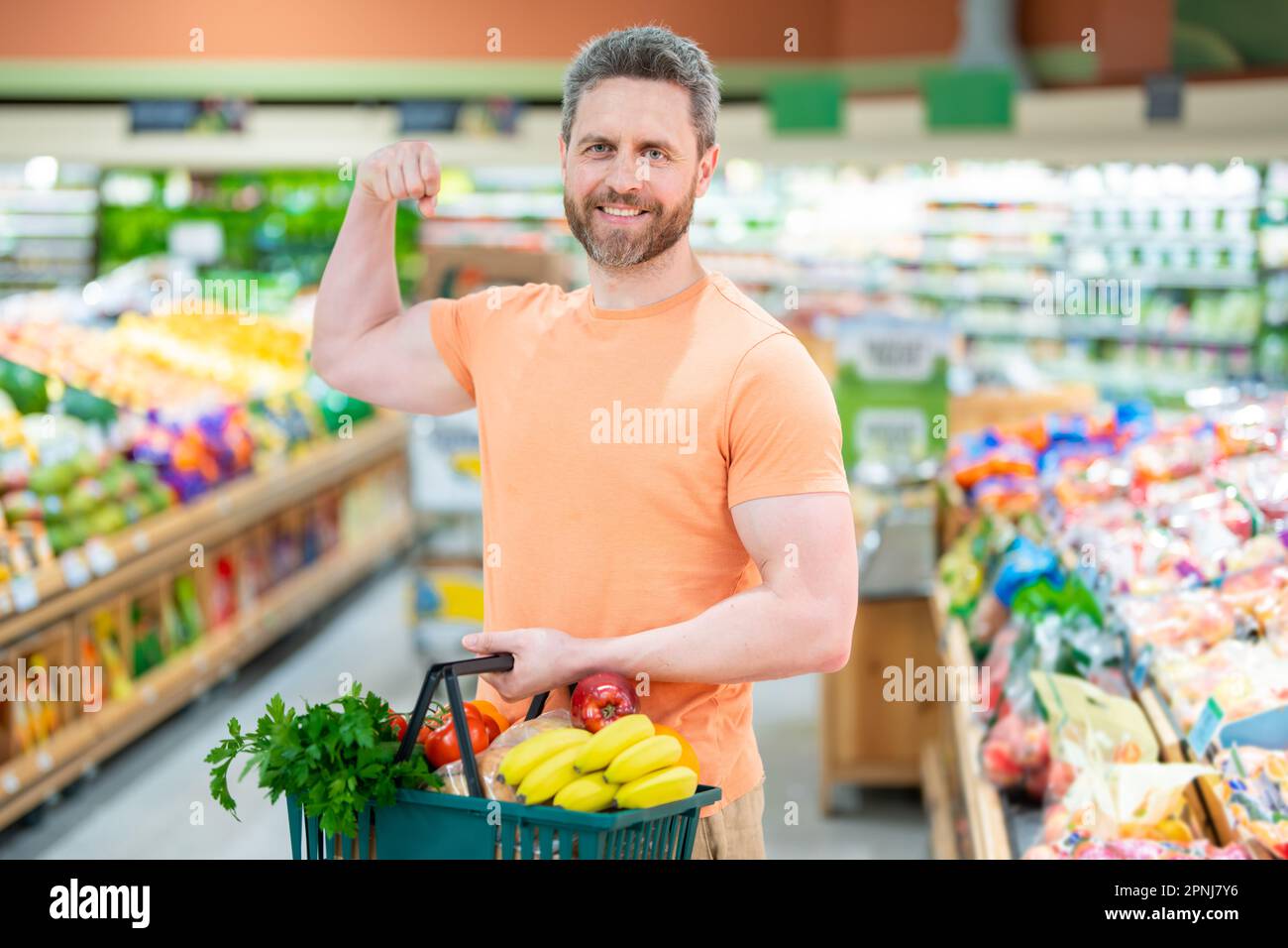 Portrait of man with shopping cart full of fresh vegetables in a food ...