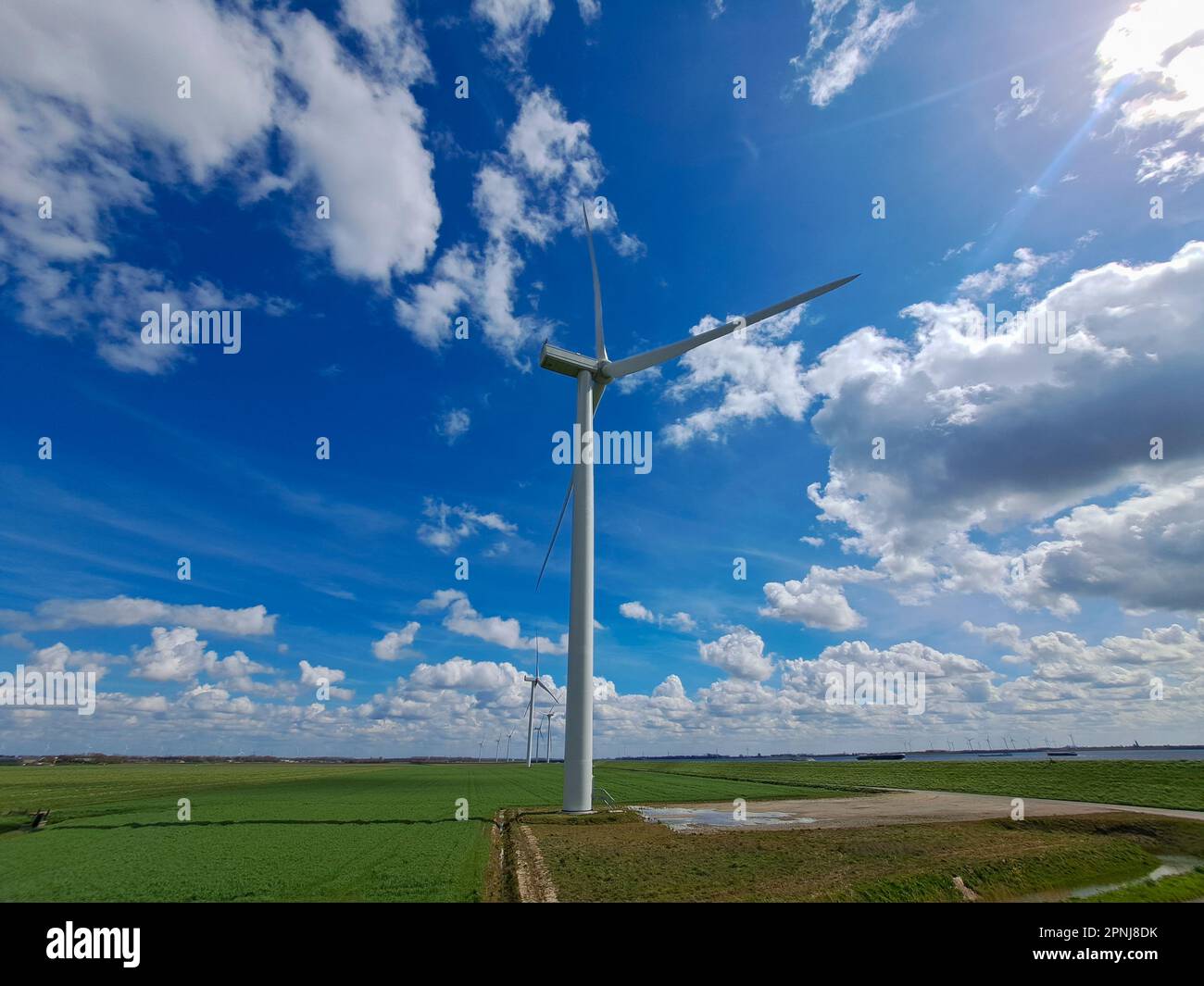 Wind turbine along dike at Ooltgensplaat on island Goeree-Overflakkee ...