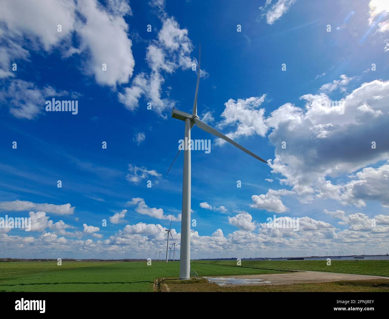 Wind turbine along dike at Ooltgensplaat on island Goeree-Overflakkee ...