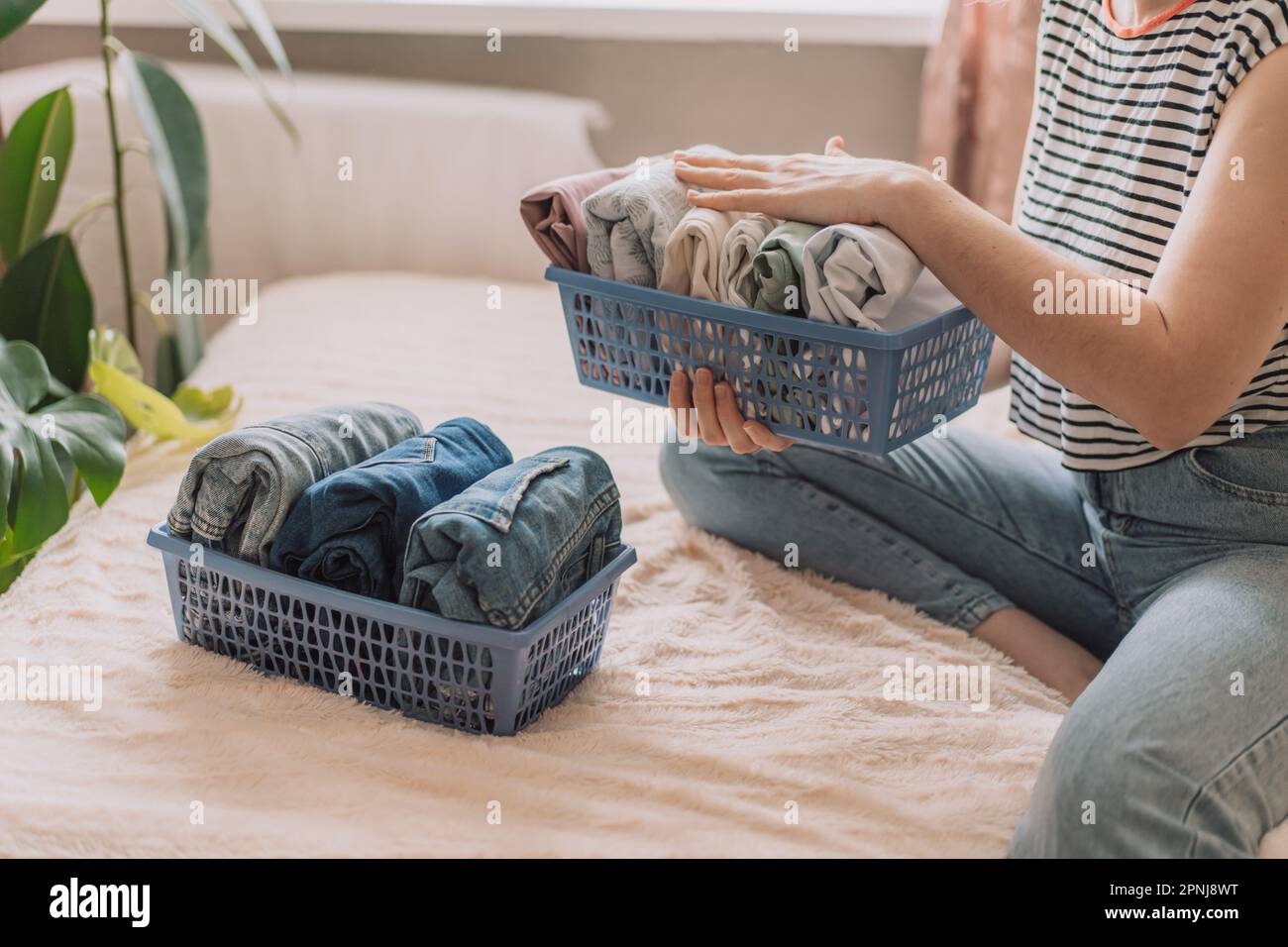 Lady organized her clothes into blue containers Stock Photo - Alamy