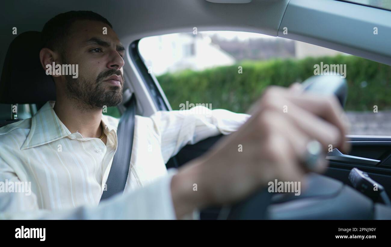 A Moroccan Arab male driving a car in an urban area with serious ...