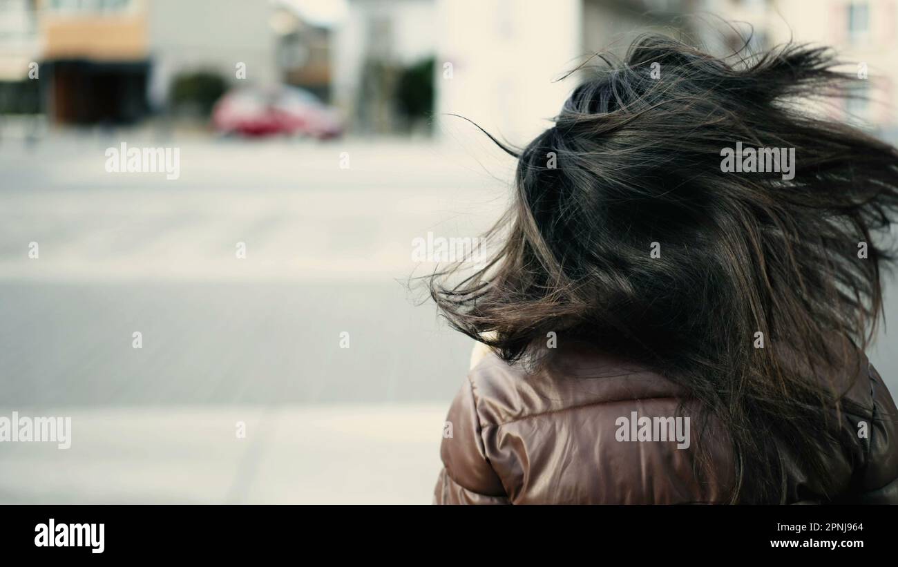 Back of Carefree young woman with long hair running outside in slow ...