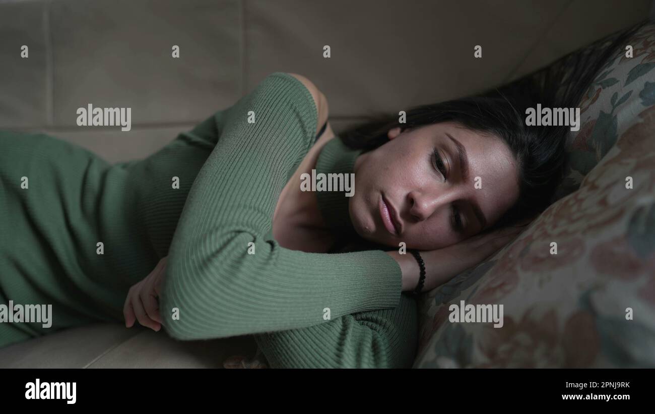 Tired woman lying on couch resting after a long day. Exhausted Adult ...