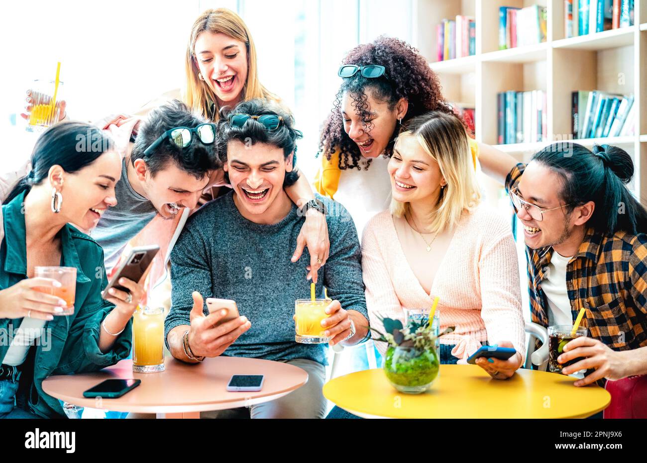 Trendy friends watching viral video on mobile phone at cocktail bar ...