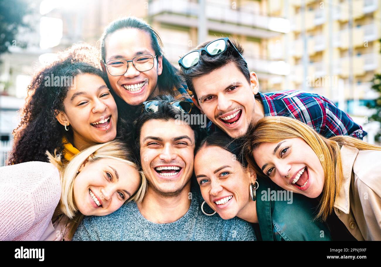 Multi ethnic guys and girls taking selfie out side with backlight ...