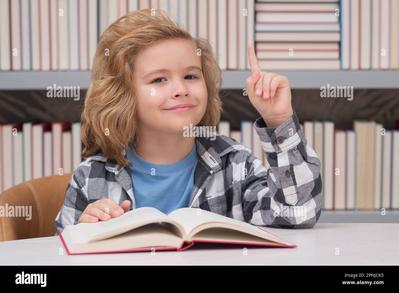 Portrait of school boy reading book in library. Kids development, learn ...