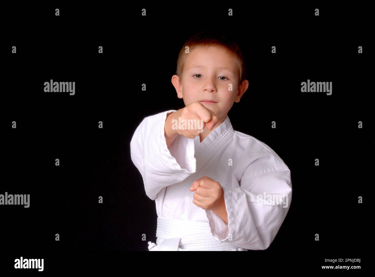 Young boy in karate outfit making fighting movement Stock Photo - Alamy