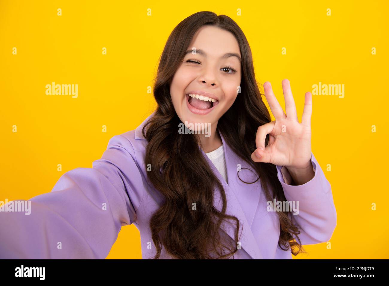 Fashion teen girl in trendy wear making selfie posing on yellow ...