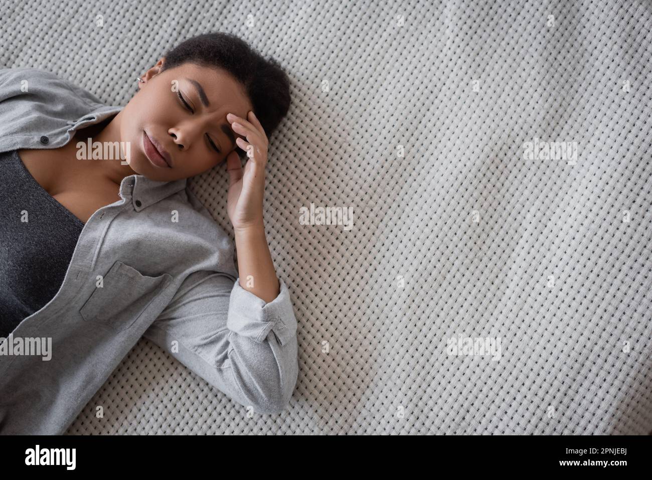 Top view of sad multiracial woman lying on bed at home,stock image ...