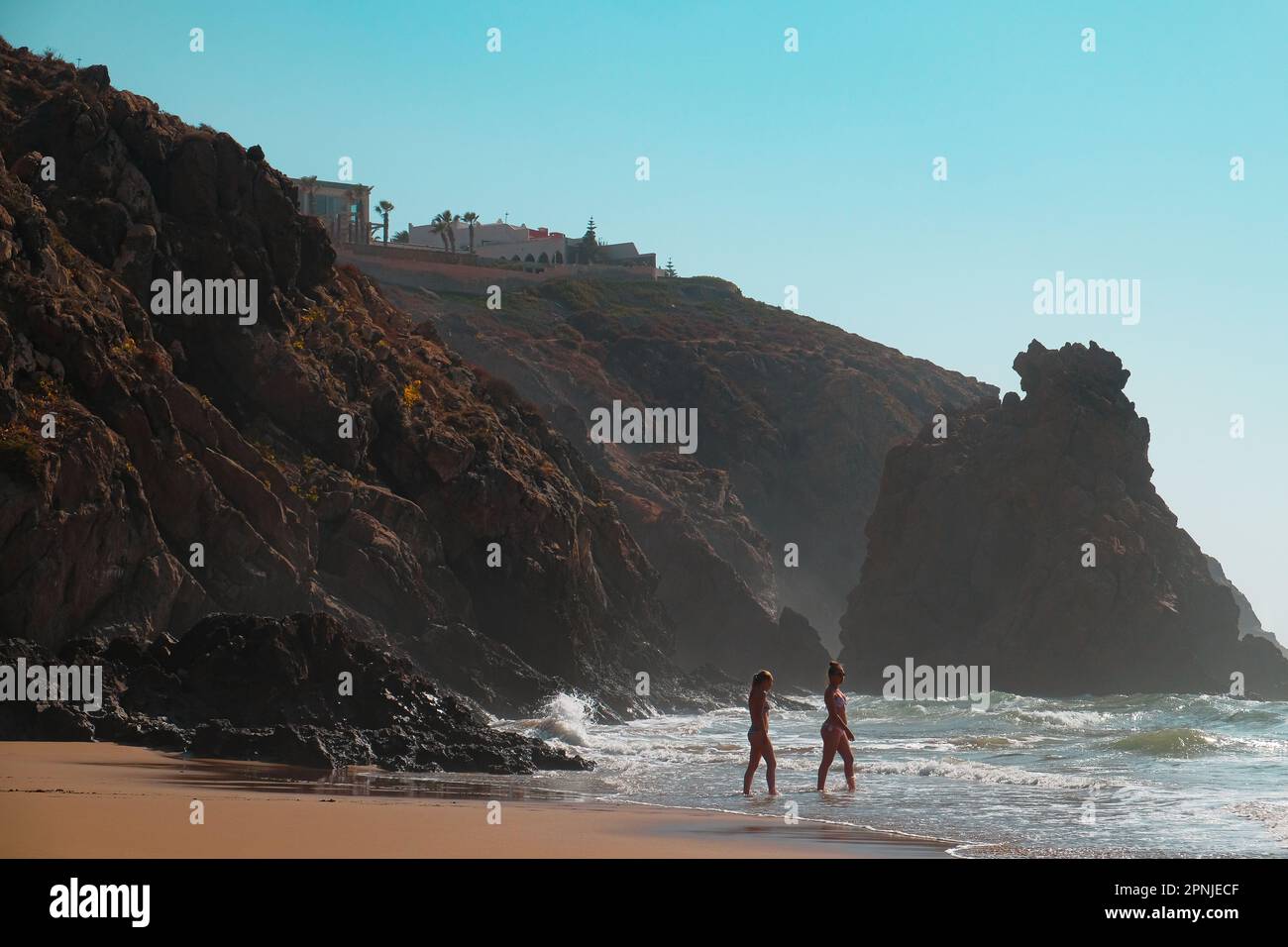 Mirleft, Morocco - two white females in bikinis walk toward the waves ...