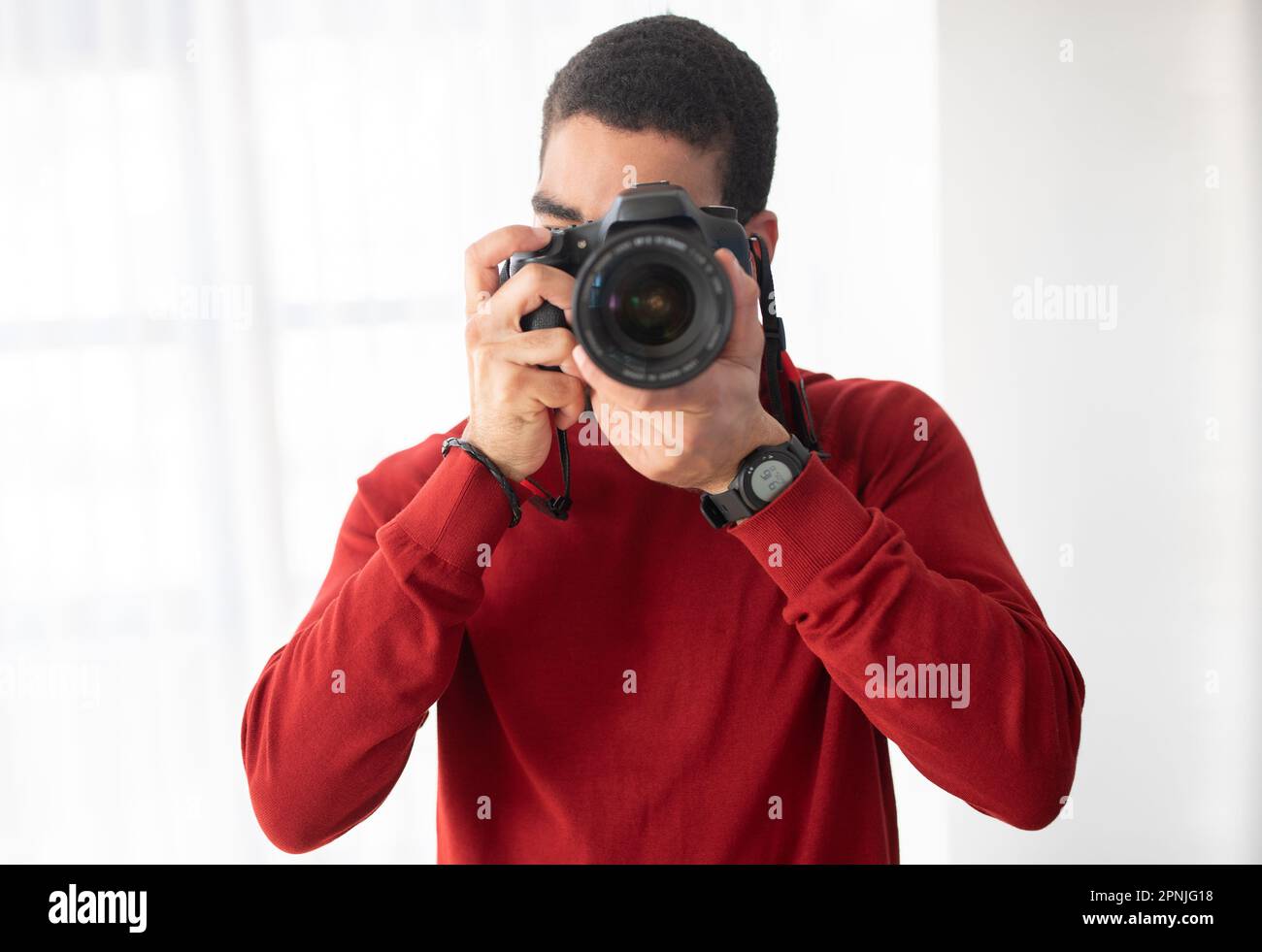 Male photographer taking photo with professional camera in studio Stock ...