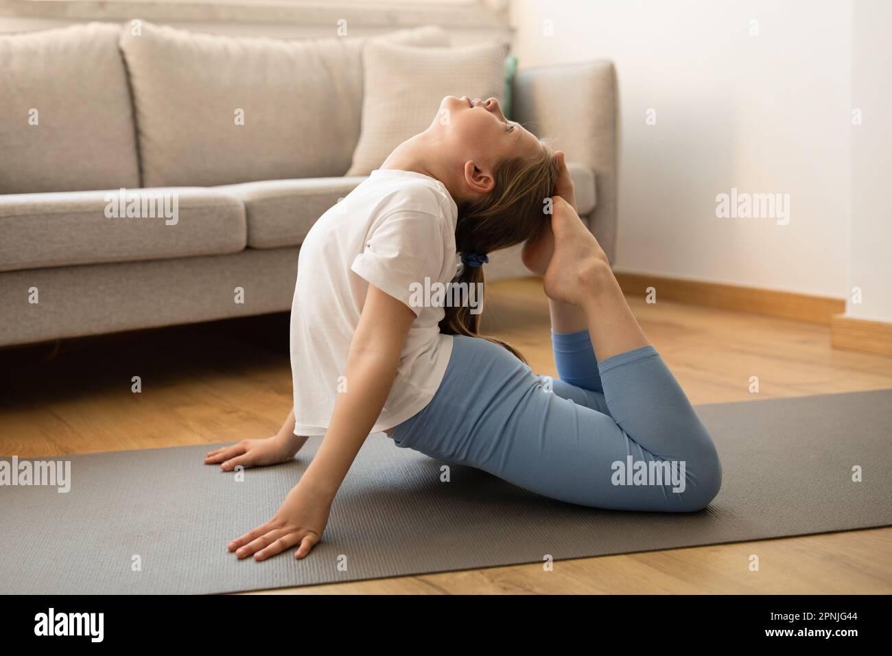 Cheerful european teenage girl athlete in sportswear doing pilates ...