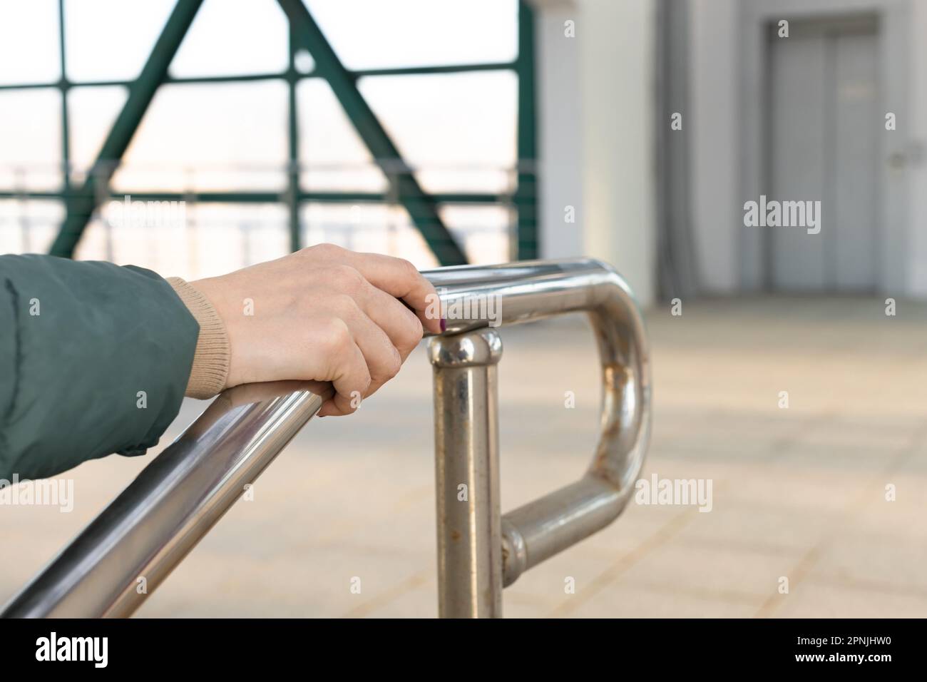 a man holding on to a handrail in a passage. hand holding onto the ...