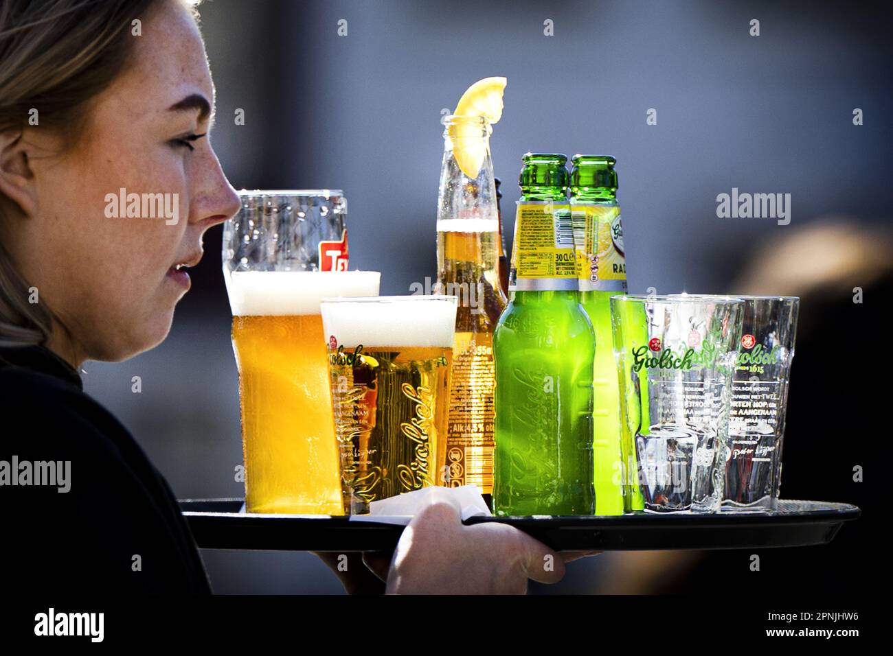 AMSTERDAM - A waiter serves different types of beer on a terrace. ANP ...