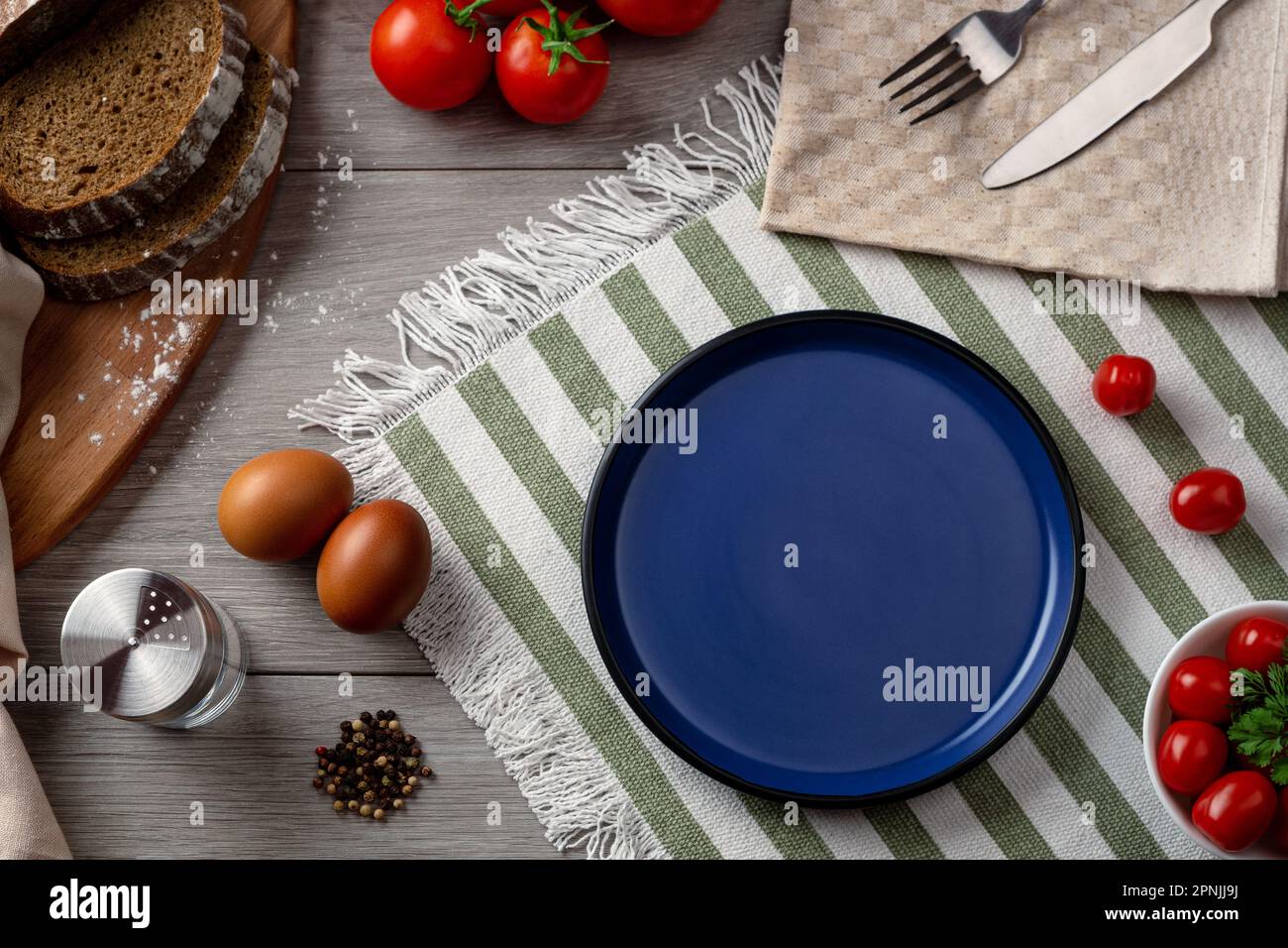 An empty blue plate as serving on the table. Table setting with ...