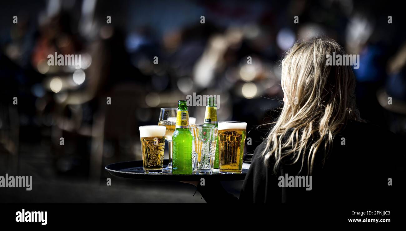 AMSTERDAM - A waiter serves different types of beer on a terrace. ANP ...