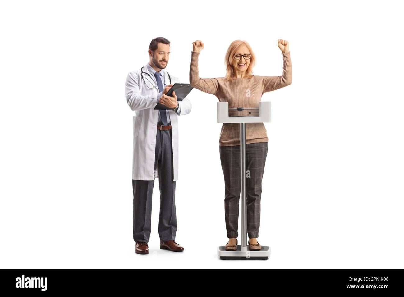 Happy woman weighing on a scale and a male doctor writing a document ...