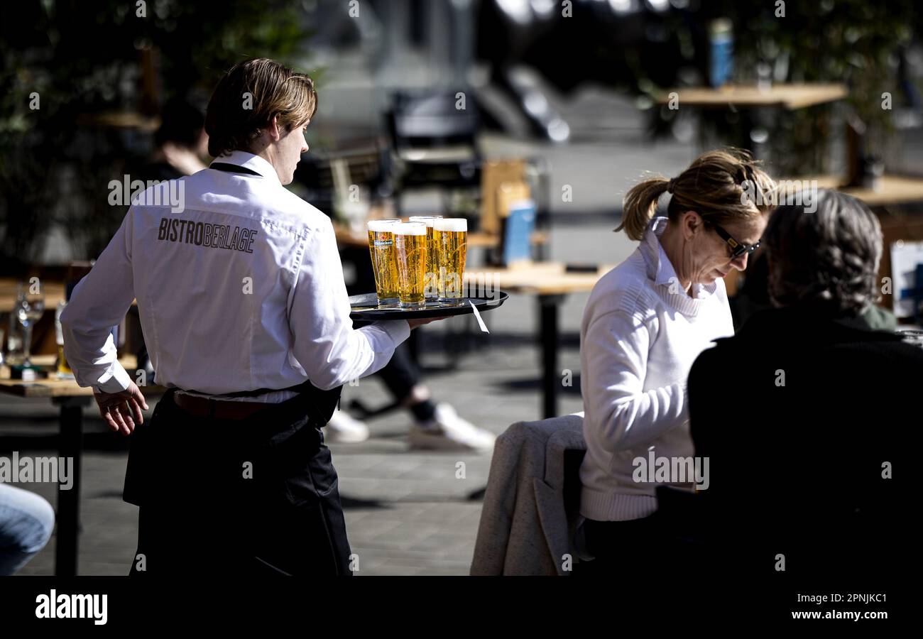 AMSTERDAM - A waiter serves beer on a terrace. ANP RAMON VAN FLYMEN ...