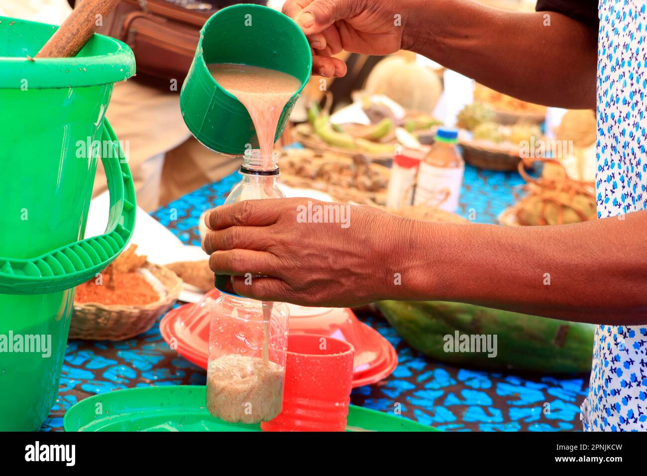 A woman is seen pouring a locally brewed drink called 'thobwa' into a ...