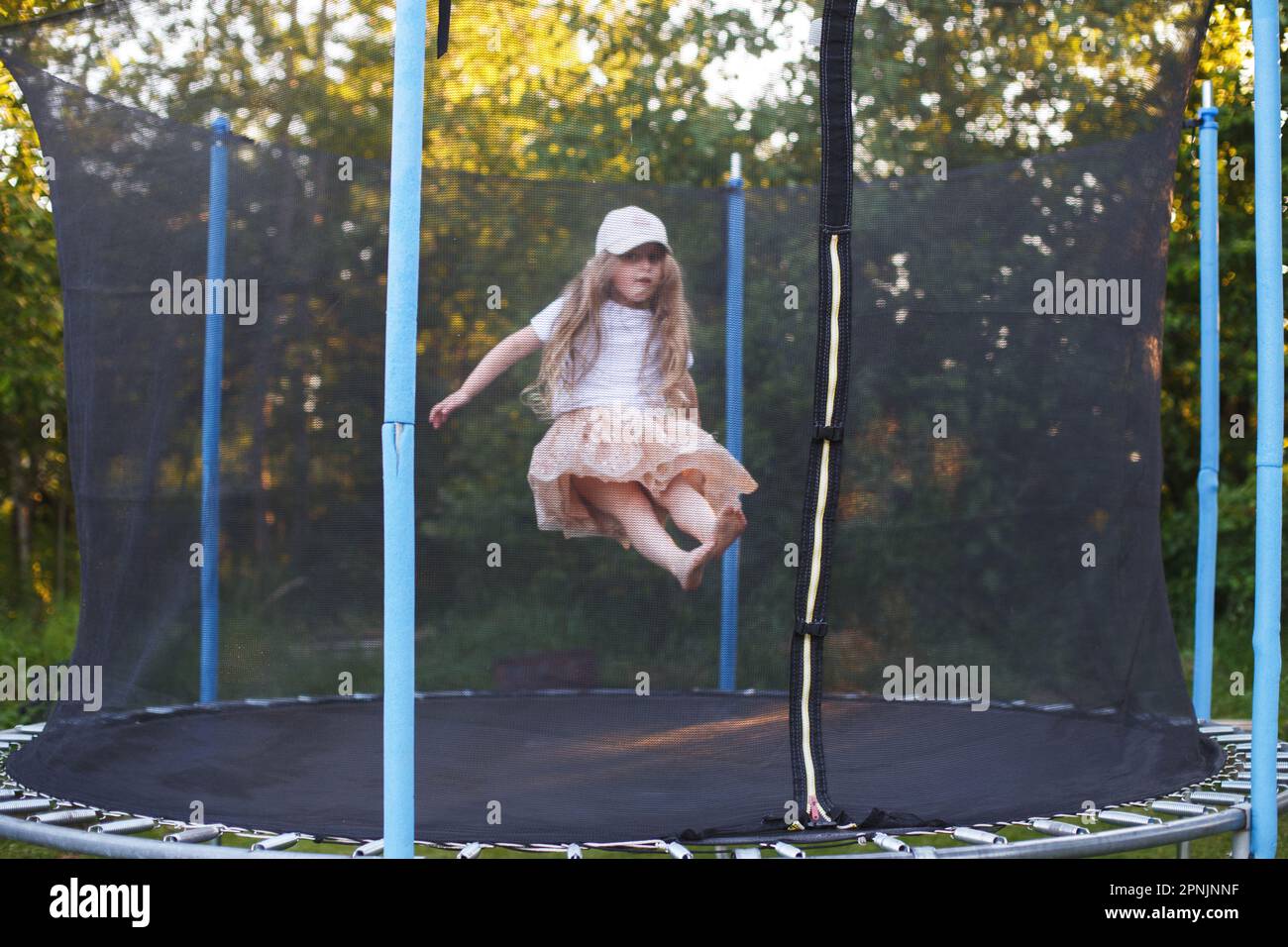 a Little child girl jumping on the trampoline in the back yard Stock ...