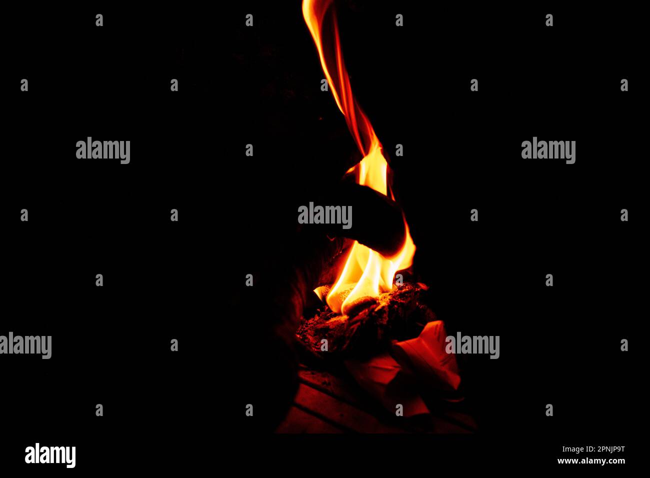 A faint flame of fire illuminates the darkness that surrounds her ...