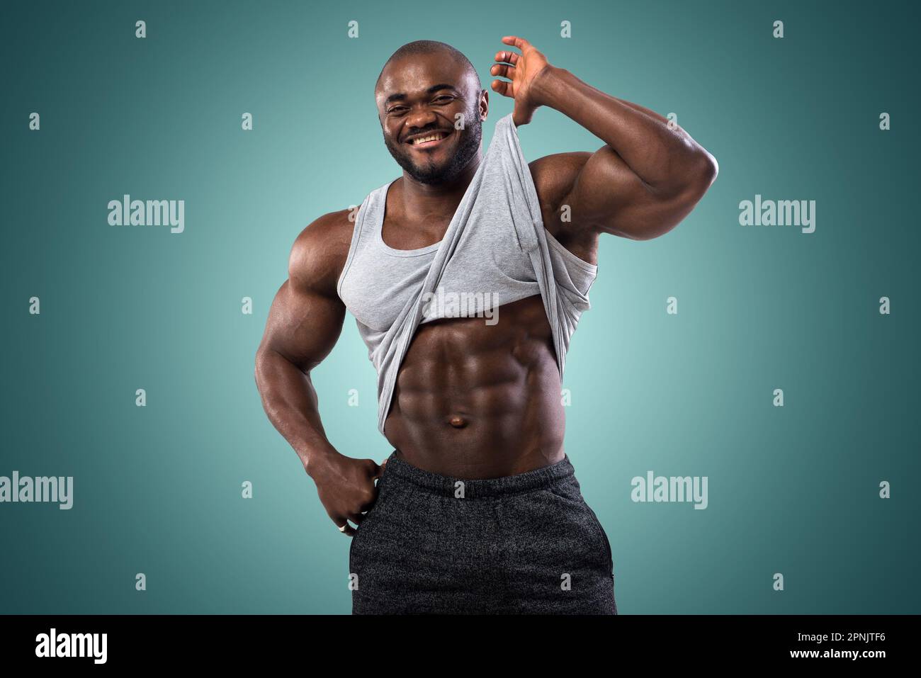 African American Athlete posing in studio. Shows the abdominal muscles ...