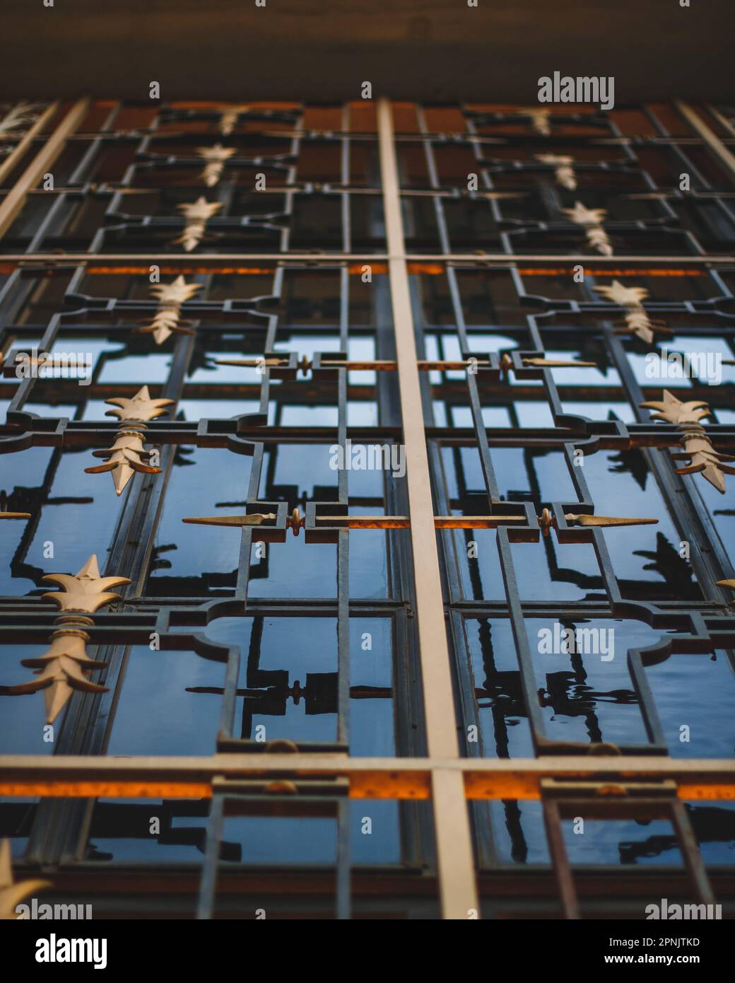 A metallic grille in a building interior, with a multitude of stars ...