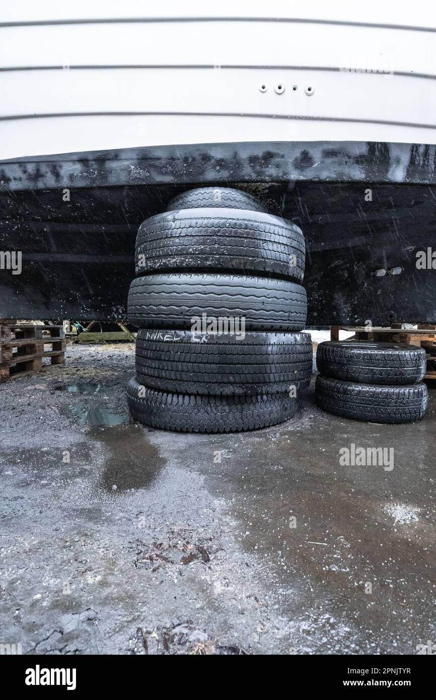 Stack of old tires supporting a boat on land Stock Photo - Alamy