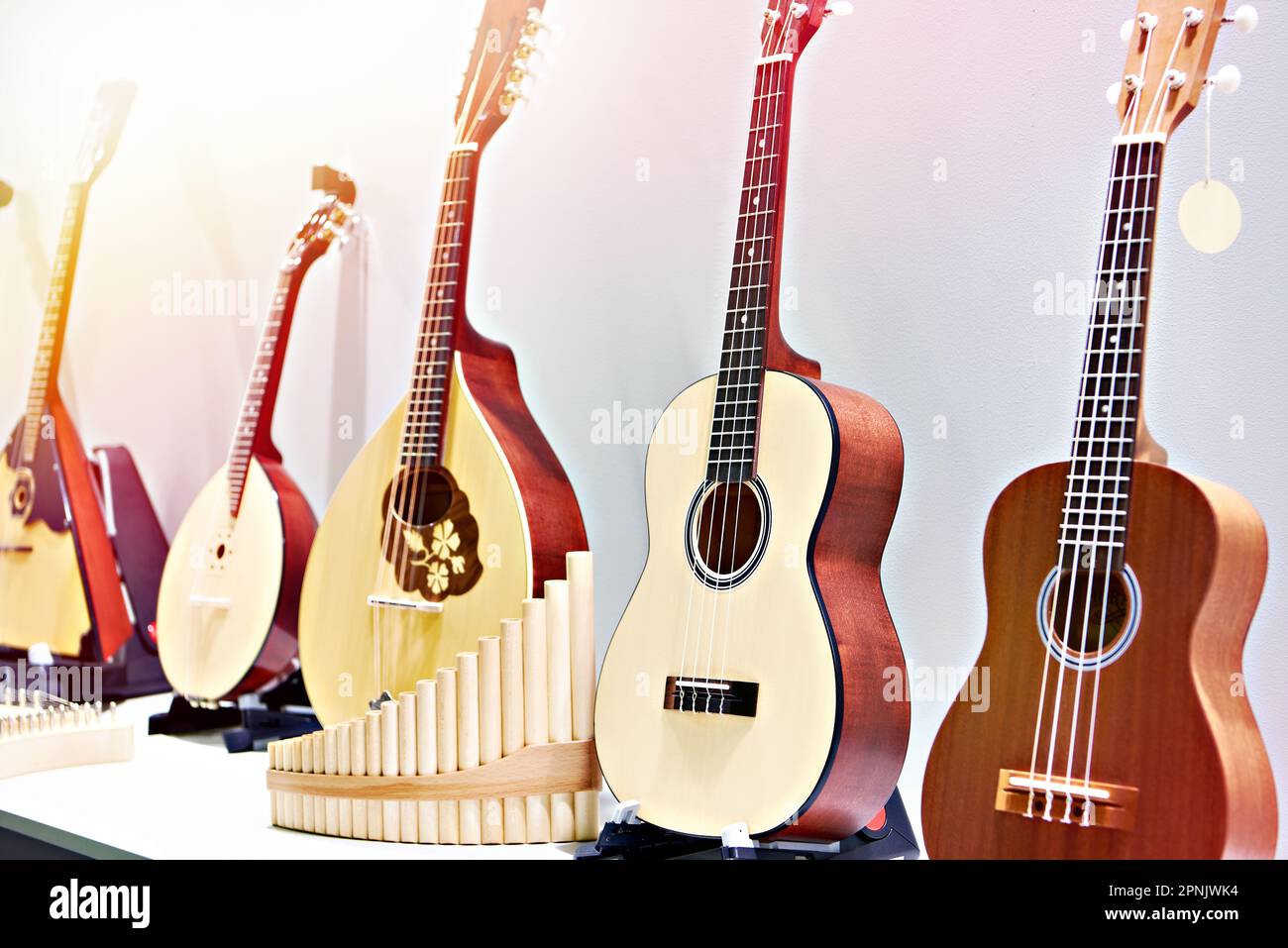 Guitars and stringed musical instruments in a store Stock Photo - Alamy