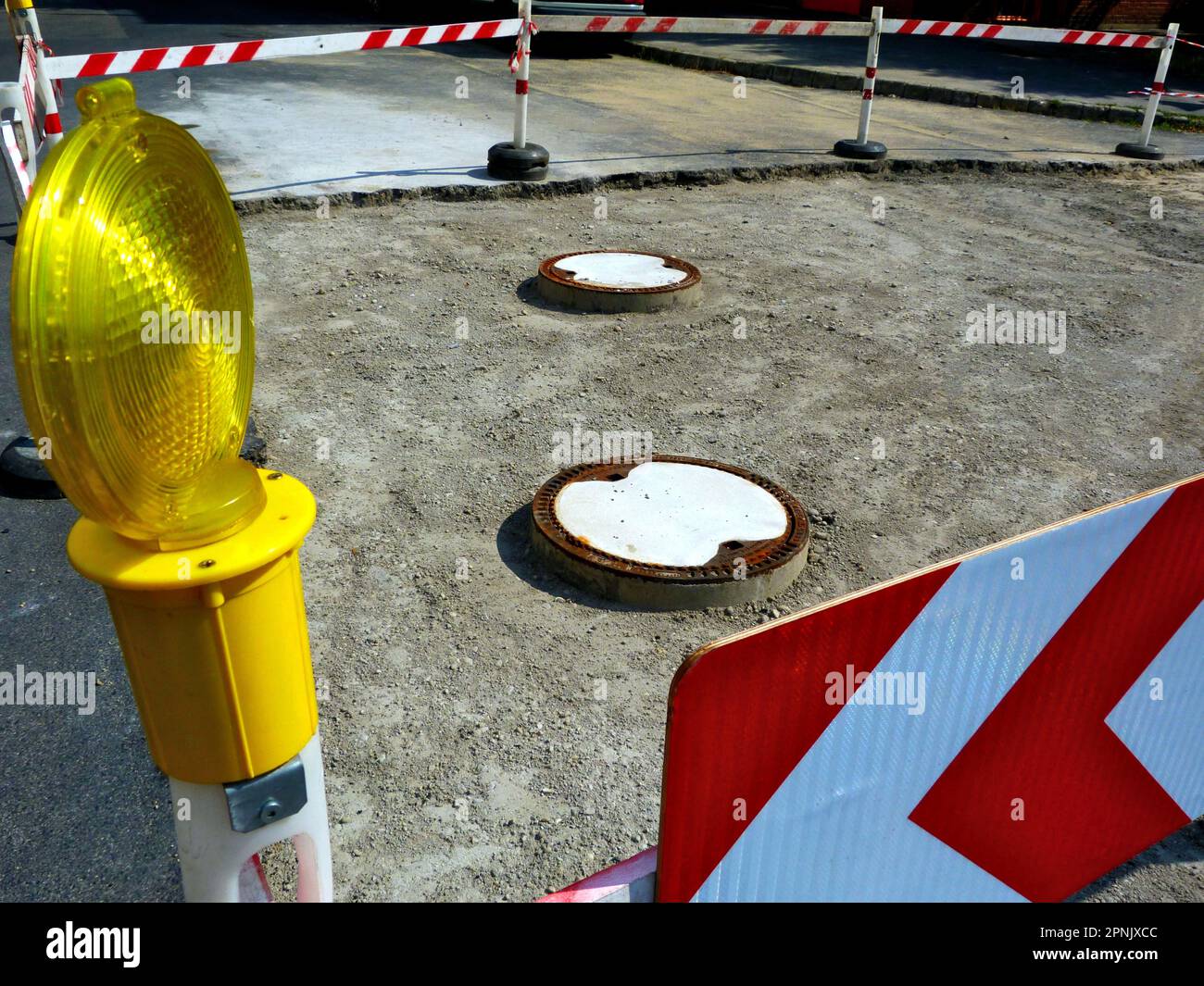 asphalt drive surface repair. exposed concrete base. manhole covers ...