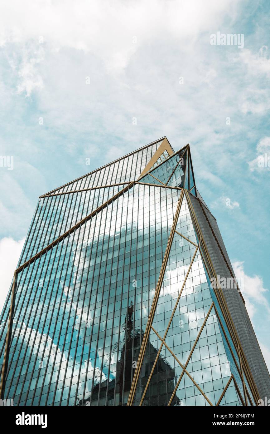 A vertical low angle shot of a modern glass skyscraper building in ...