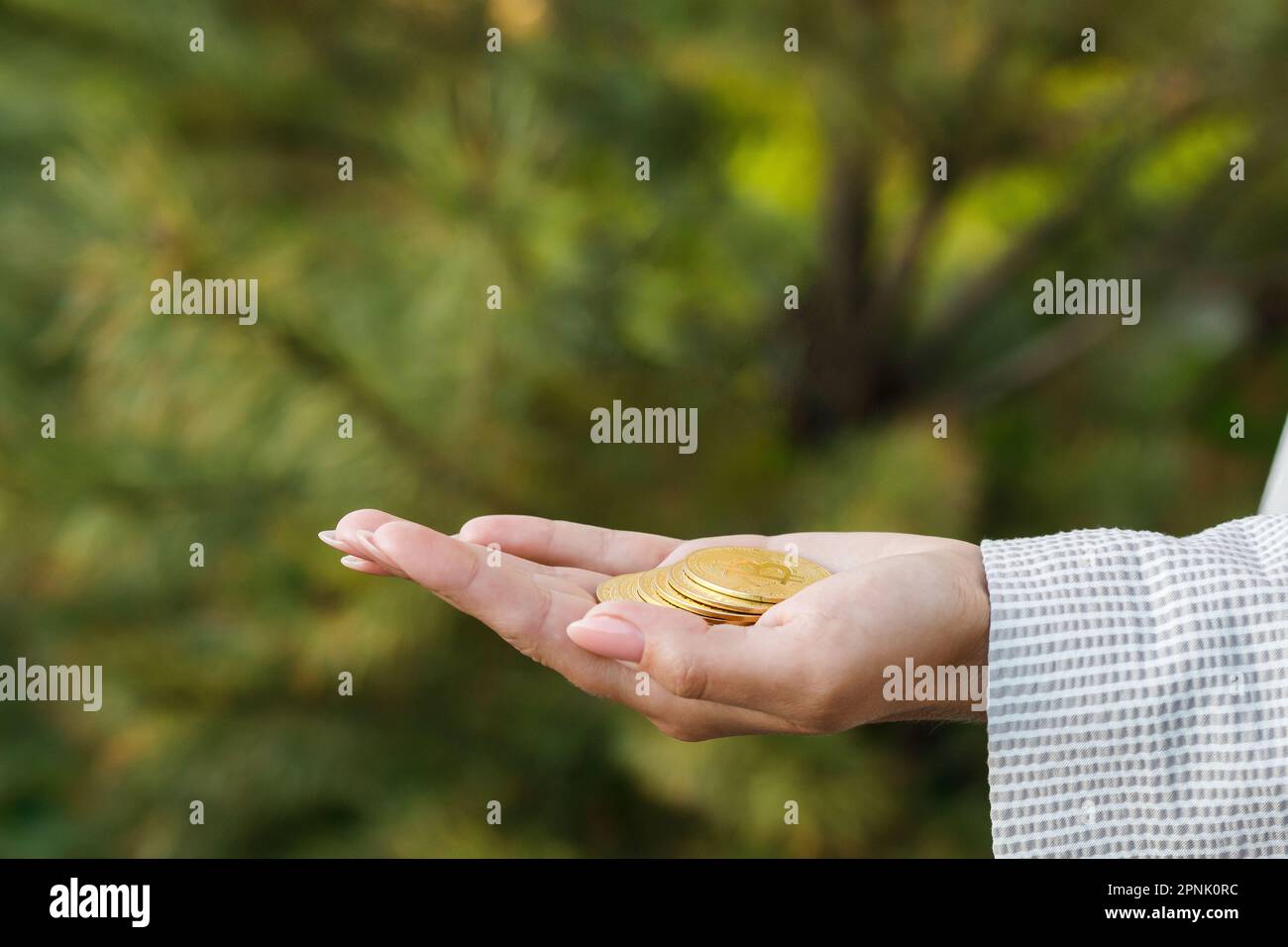 Bitcoin falling concept. Close up of a female hand holding a coin and ...