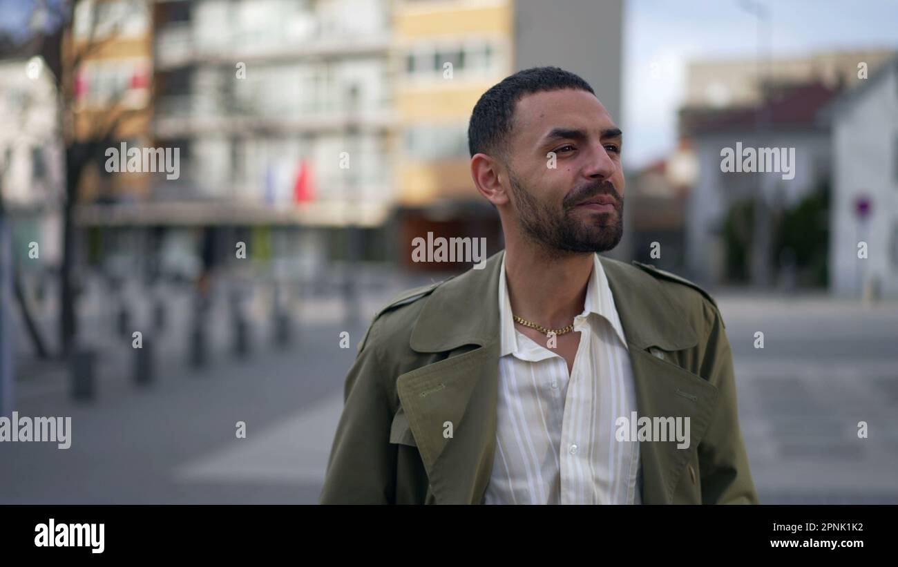 One happy young Middle Eastern man standing in city street smiling with ...
