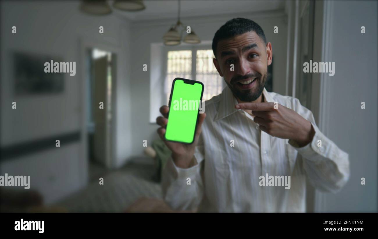 One happy Arab man showing smartphone device screen with chroma key ...