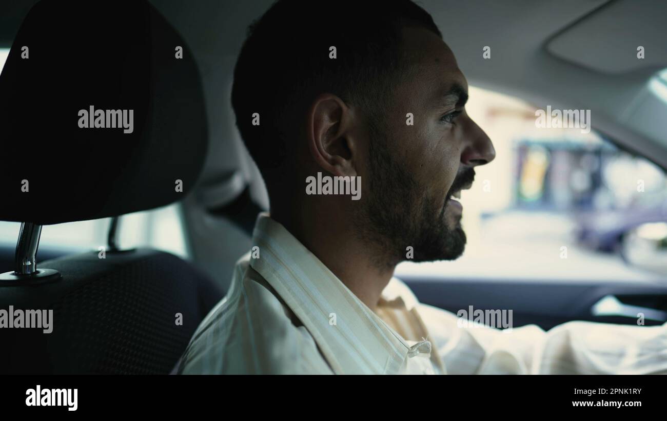 One happy Middle Eastern man driving car. Inside perspective of a male ...