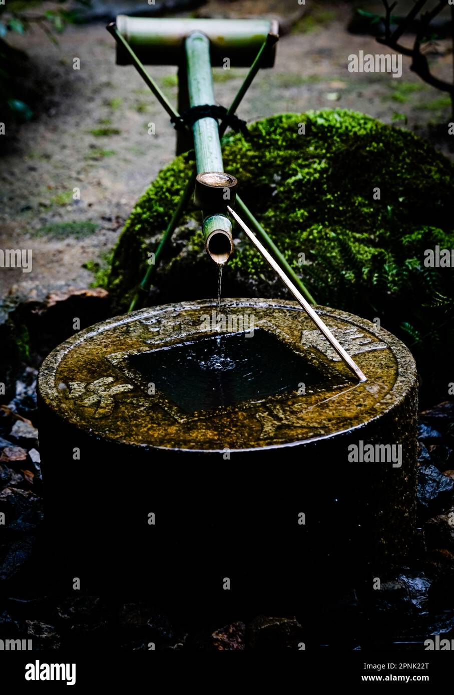 Tsukubai, or stone water basin, with a bamboo dipper, hisaku, for ...