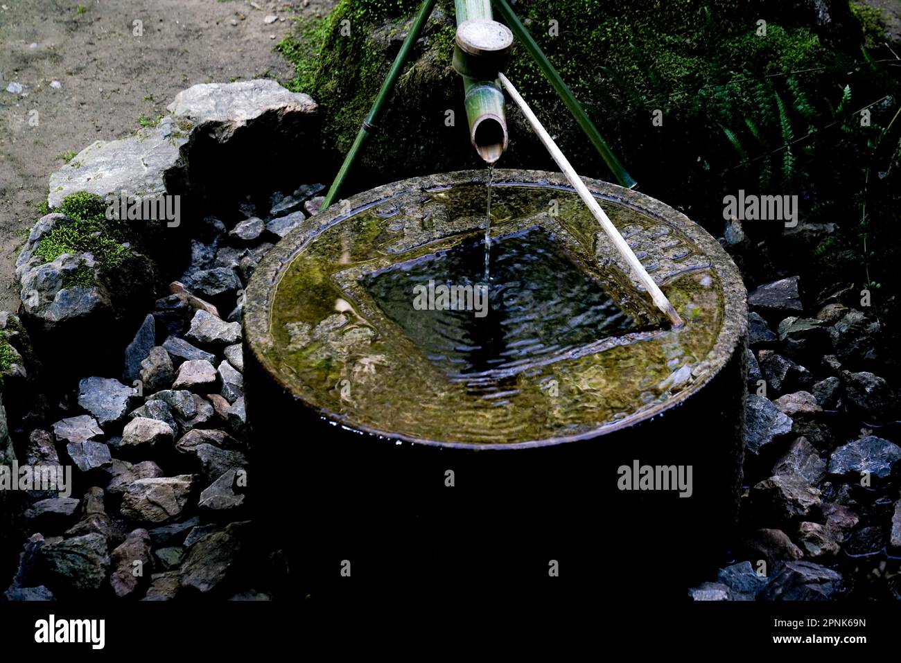Tsukubai, or stone water basin, with a bamboo dipper, hisaku, for ...