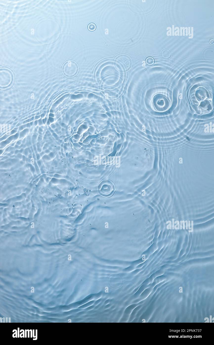 An array of water droplets cascading across the surface of the water ...