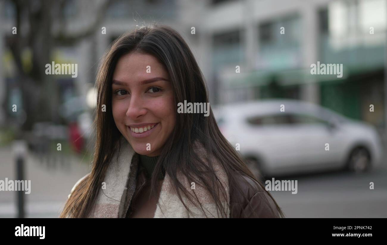 One woman close up face stands in city street in tracking shot ...