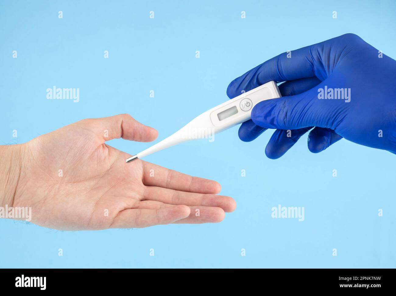 The doctor in blue latex gloves passes the digital thermometer into the ...