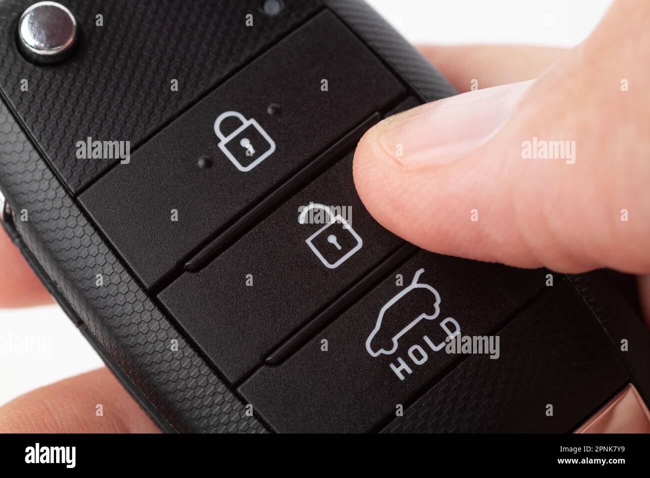Unlocking a car with button on the keychain. Man's hand holds car key ...