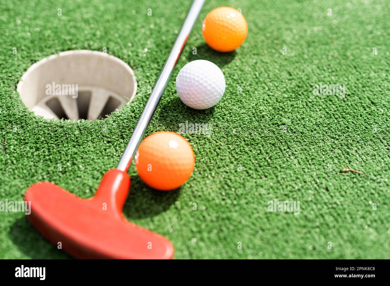 Mini golf ball on green headed towards hole Stock Photo - Alamy