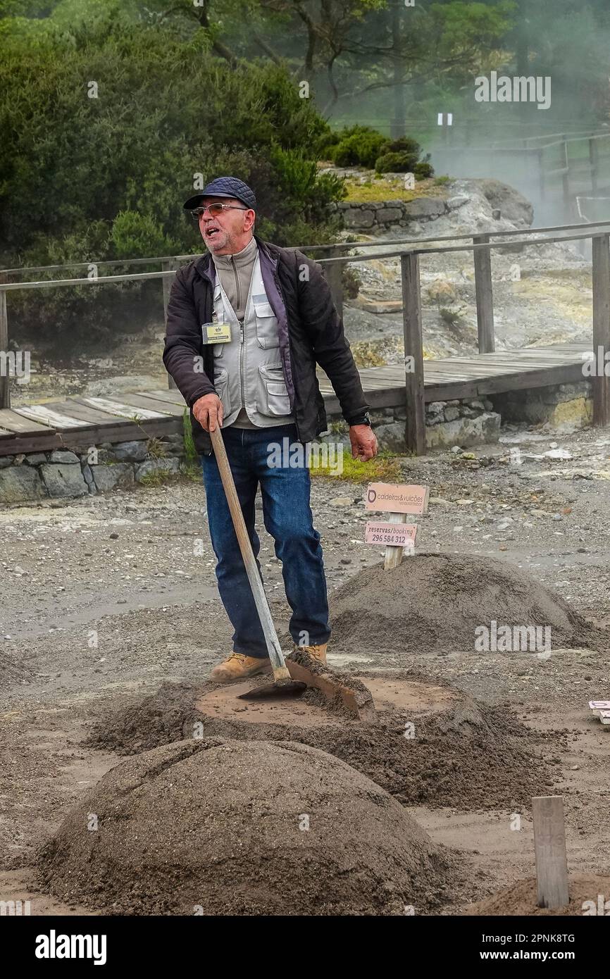 A worker uncovers a geothermal pit called a fumarole used to prepare ...